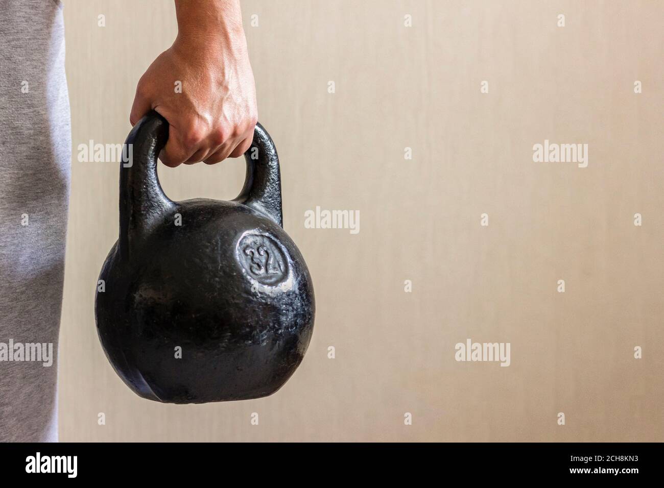 Strong male hand holding a two-pound cast-iron weight close-up Stock ...