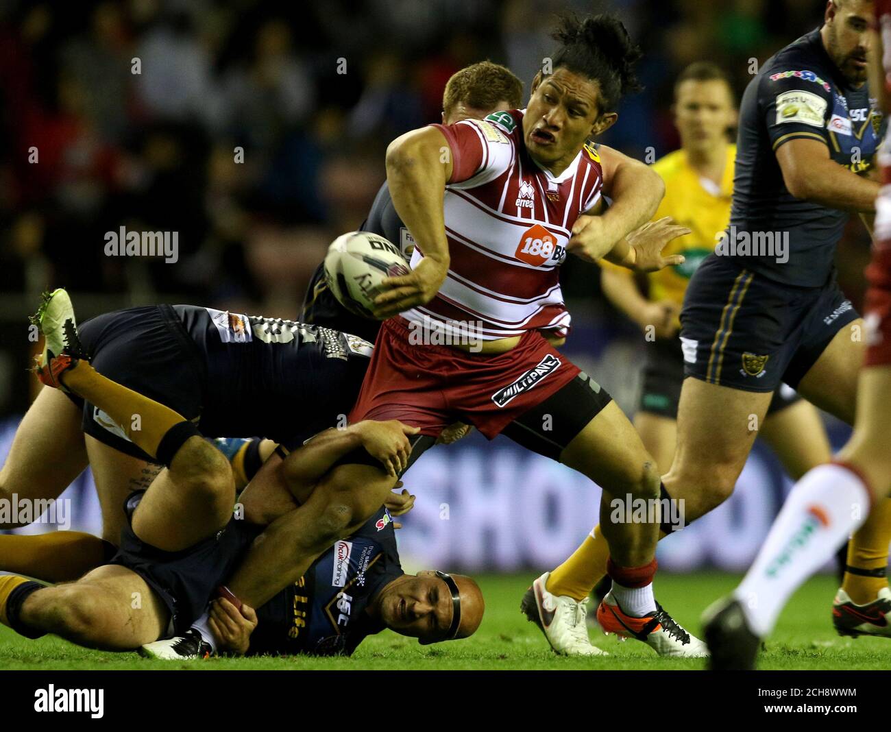 Wigan Warriors' Taulima Tautai off-loads as he is tackled during the ...