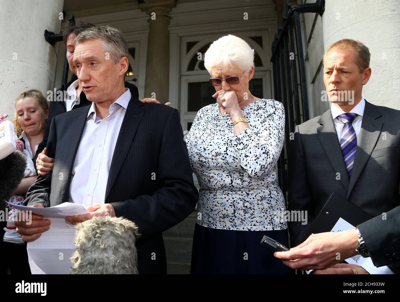 Maureen Lock (second right), the widow of Donald Lock, puts her hand on ...