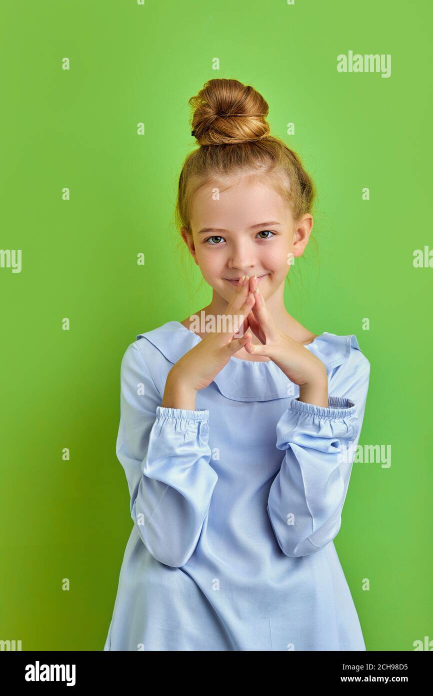 intelligent caucasian kid girl is thinking about something, keep hands ...