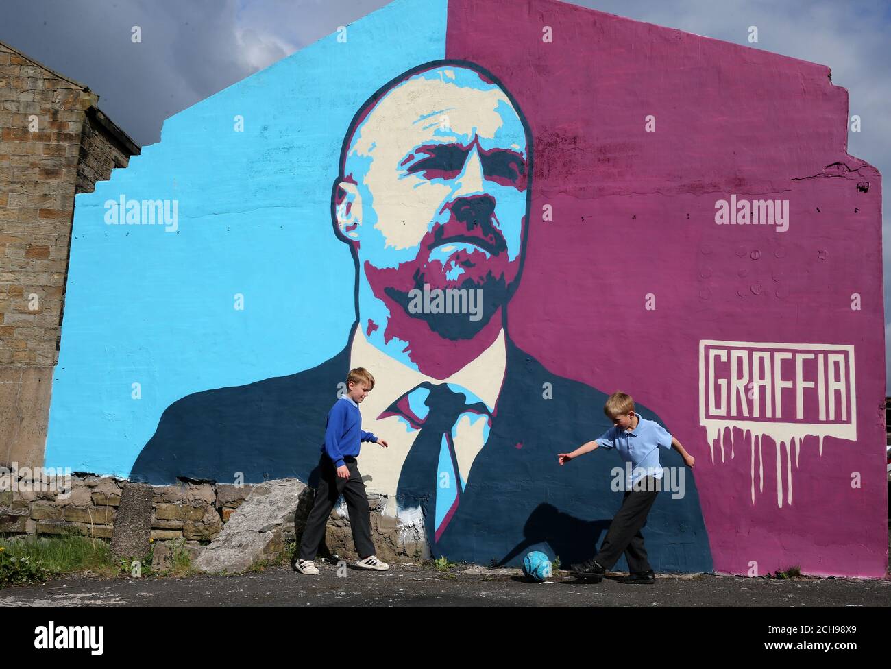 Charlie (left) and Toby Birtwhistle play football in front of a mural ...