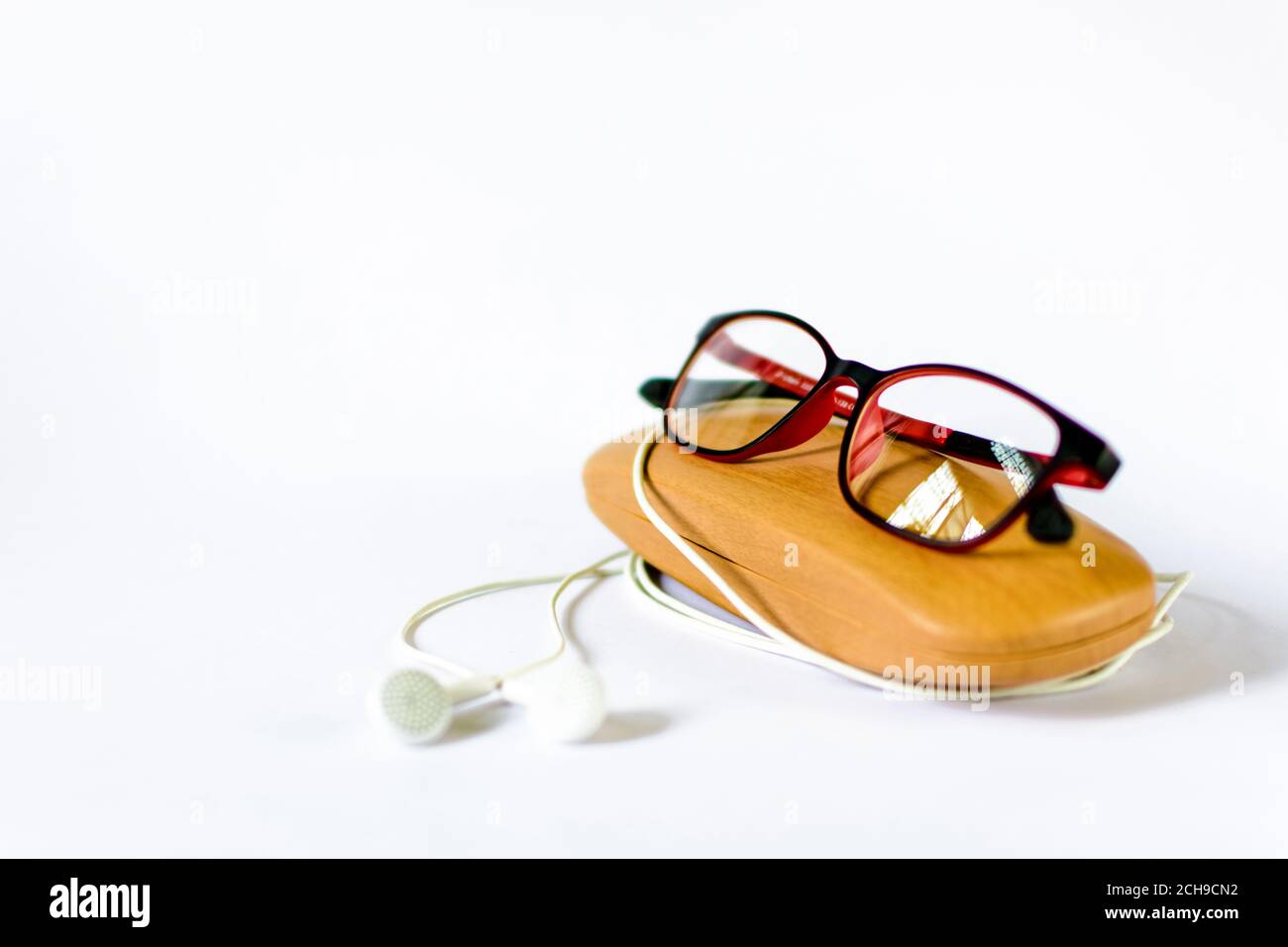 specs, specs box and earphone on white background blurred shallow depth ...