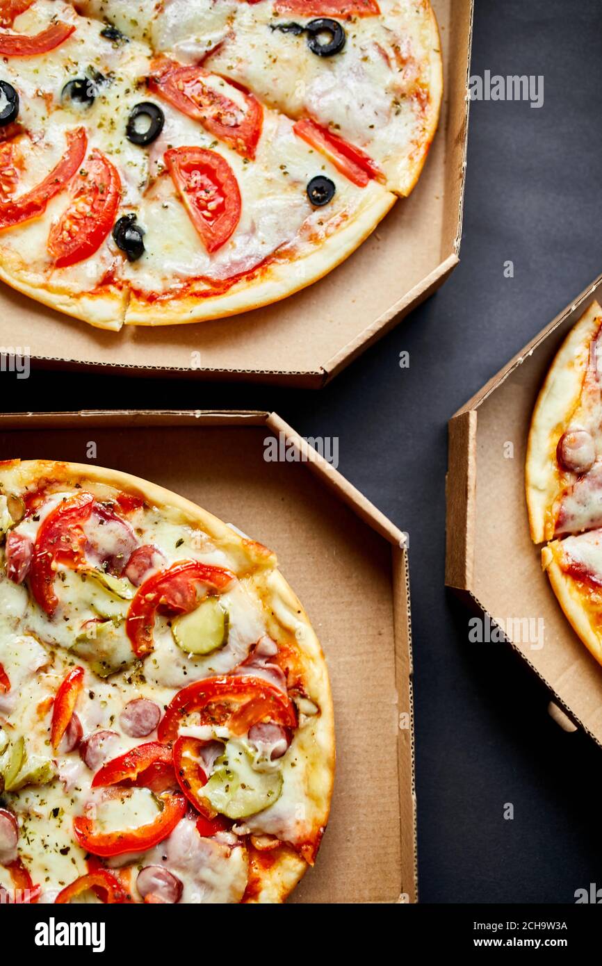 Open box with hot tasty italian sliced pizza on black background Stock ...