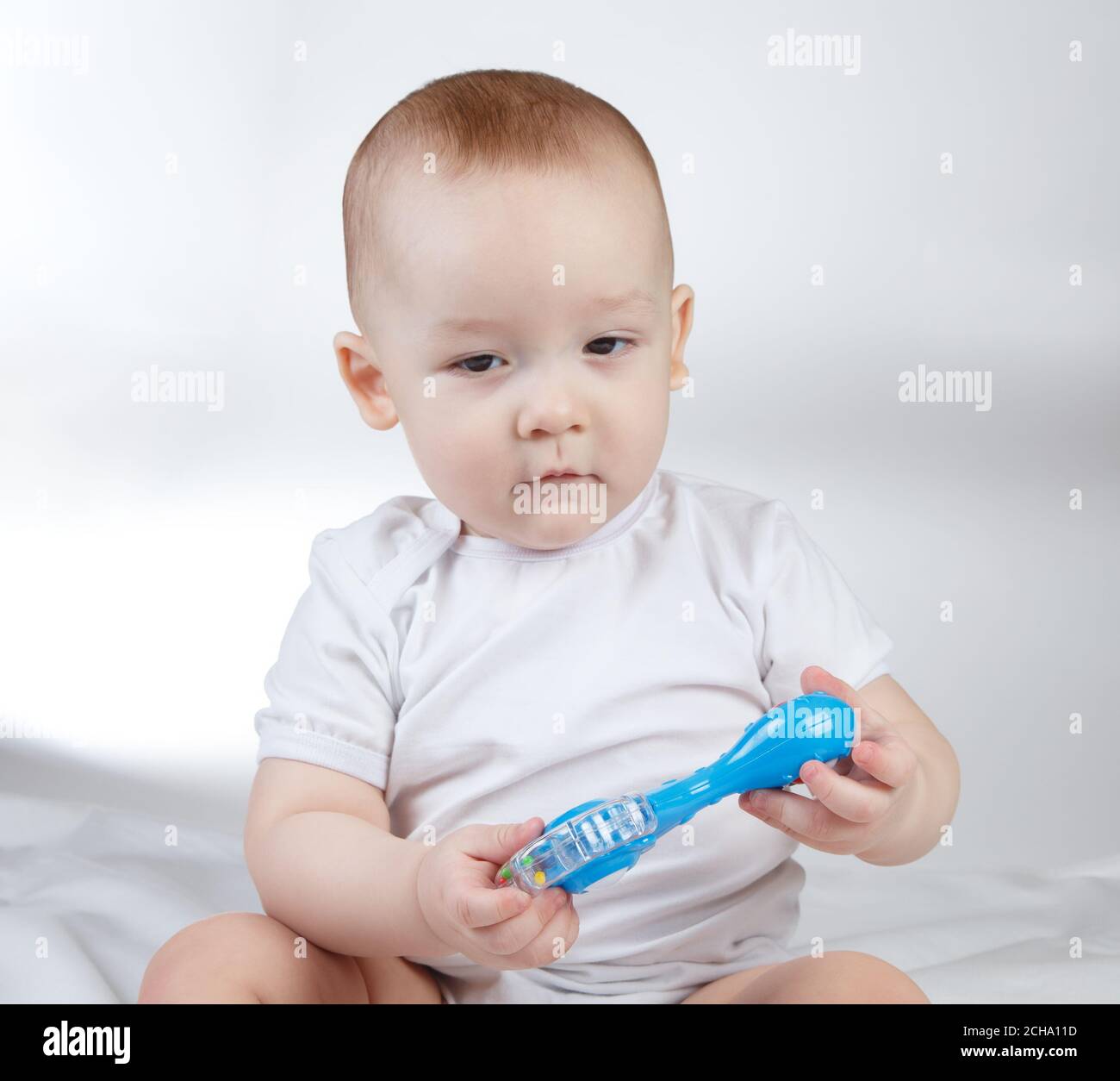 Photo of a ten-month-old baby boy with blue rattle Stock Photo - Alamy