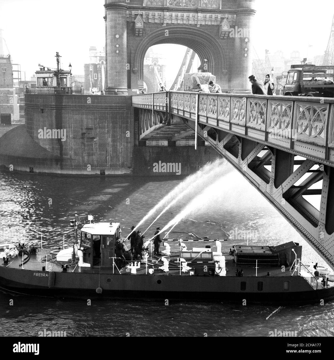 A River Thames fireboat of the London Fire Brigade tend to a fire ...