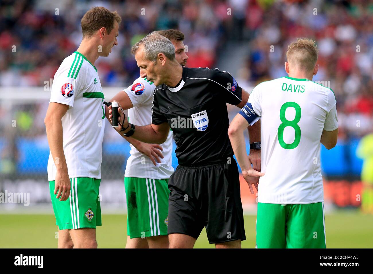Match referee Martin Atkinson (centre) with Northern Ireland's Jonny ...