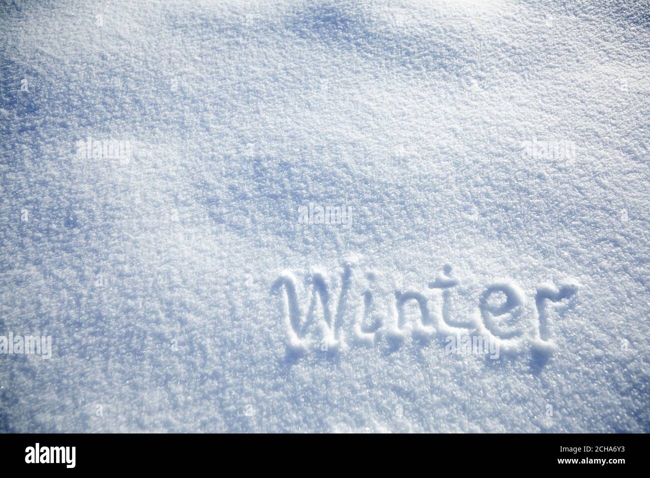 inscription winter on snowy background, text on snow surface with copy ...