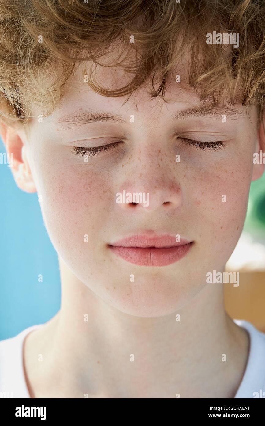 portrait of dreamy calm boy with eyes closed, freckled boy in ...