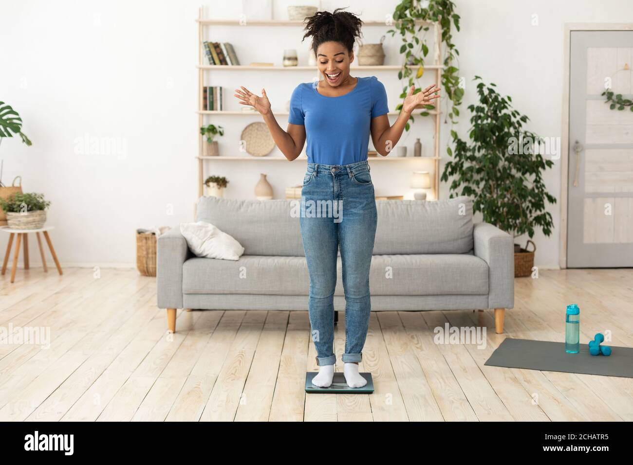Excited Slim Black Girl Standing On Weight-Scales At Home, Full-Length ...