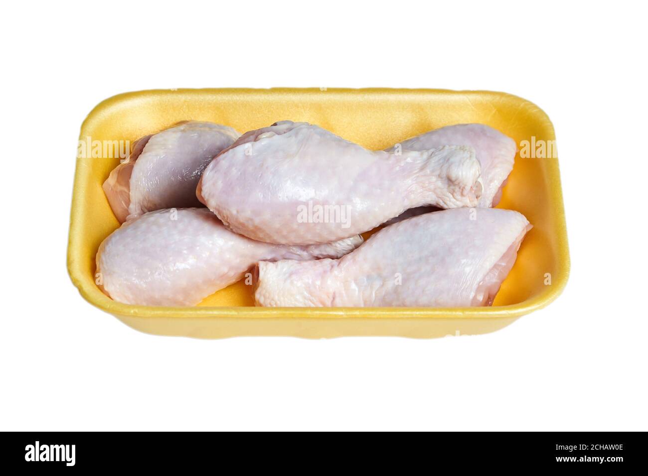 Uncooked chicken legs with skin in a yellow plastic container. Fresh ...