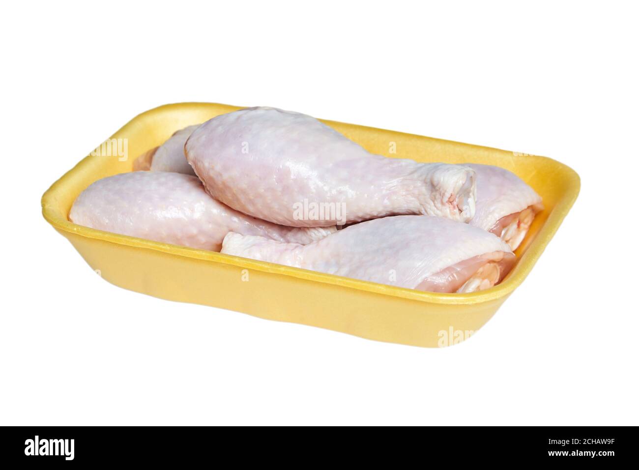 Uncooked chicken legs with skin in a yellow plastic container. Fresh ...