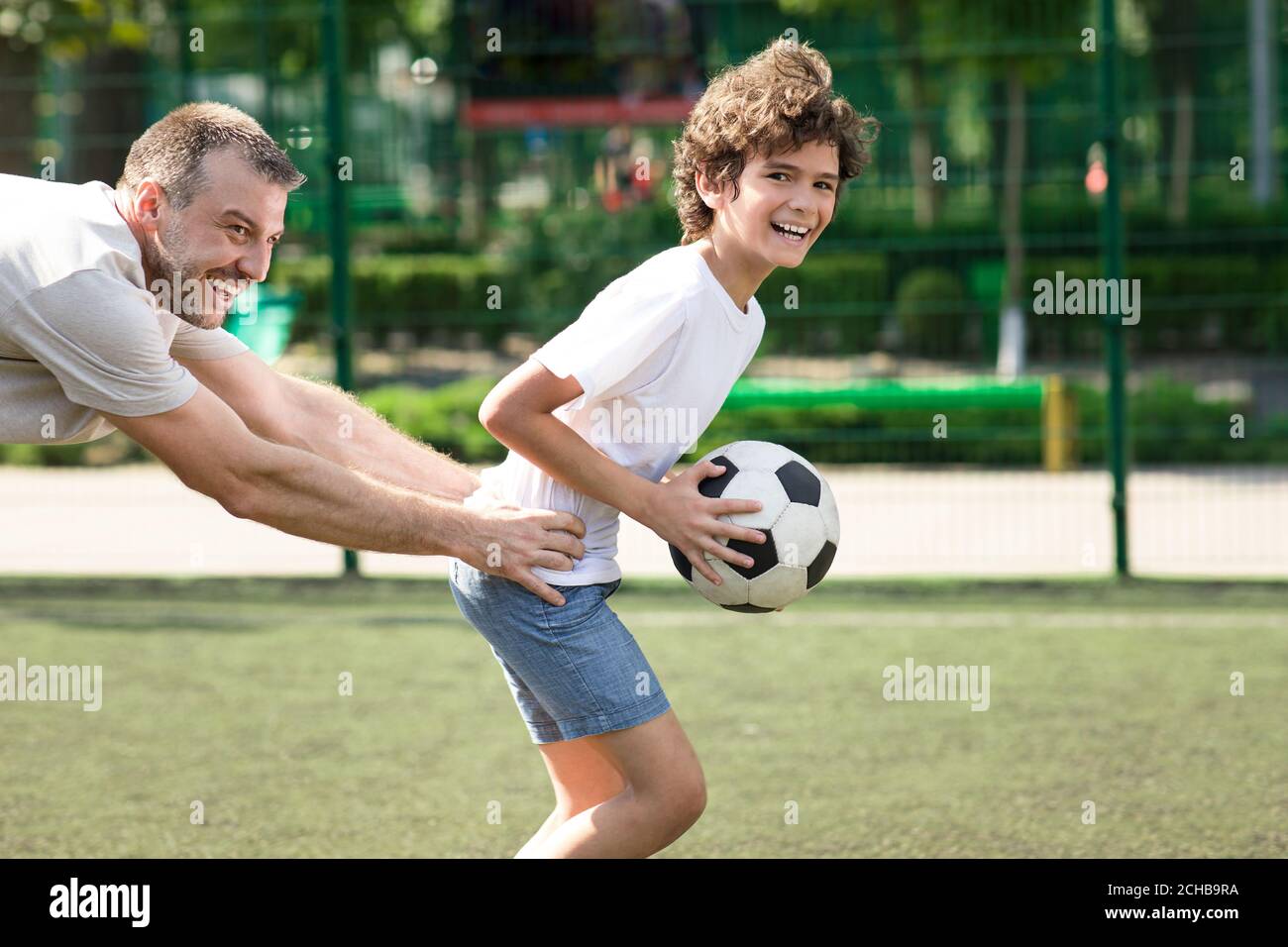 Dad spending time with his son at playground, playing soccer Stock ...