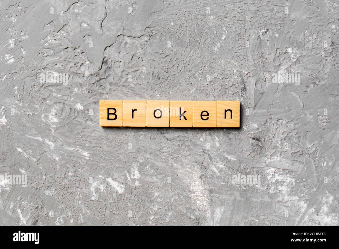 BROKEN word written on wood block. BROKEN text on cement table for your ...