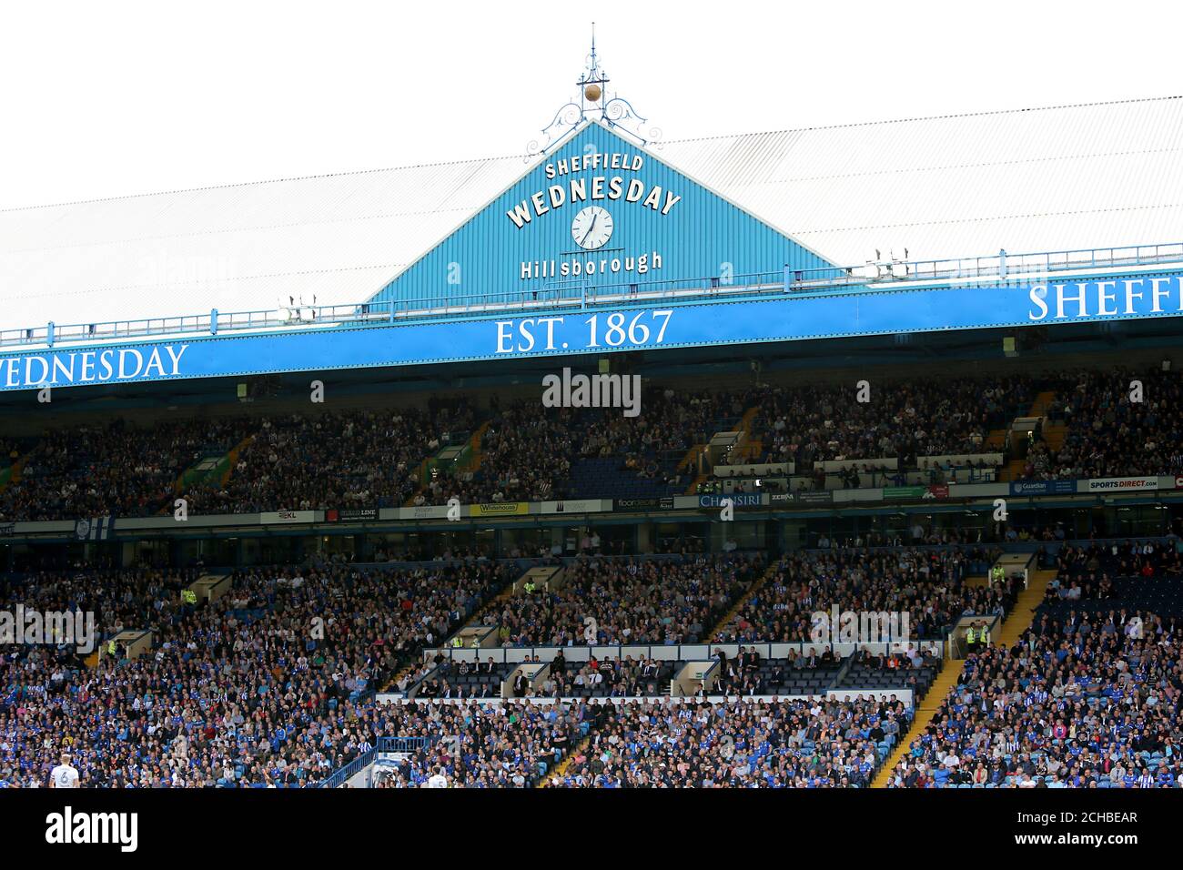 General view of the Hillsborough Stadium clock with fans in the stands ...