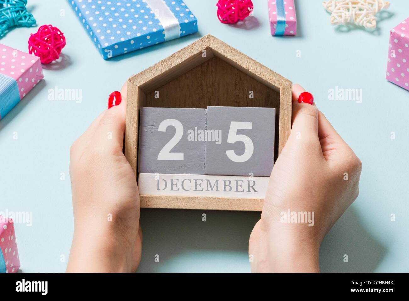 Top view of female hands holding calendar on purple background. The ...