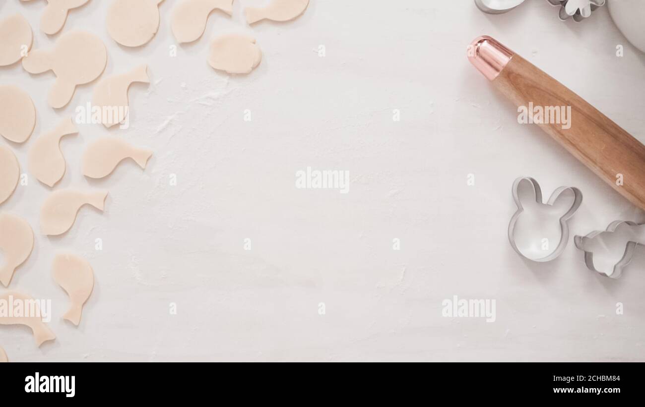 Step by step. Flat lay. Cutting sugar cookie dough with Easter shaped ...