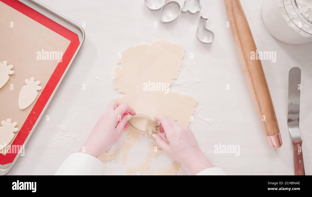 Step by step. Flat lay. Cutting sugar cookie dough with Easter shaped ...