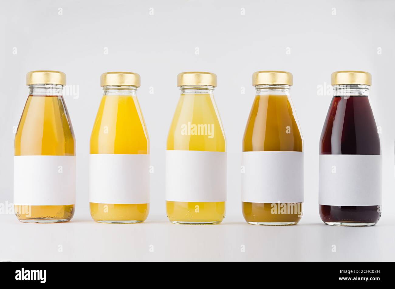 Yellow, orange, red fruit juices large collection in glass bottles with ...