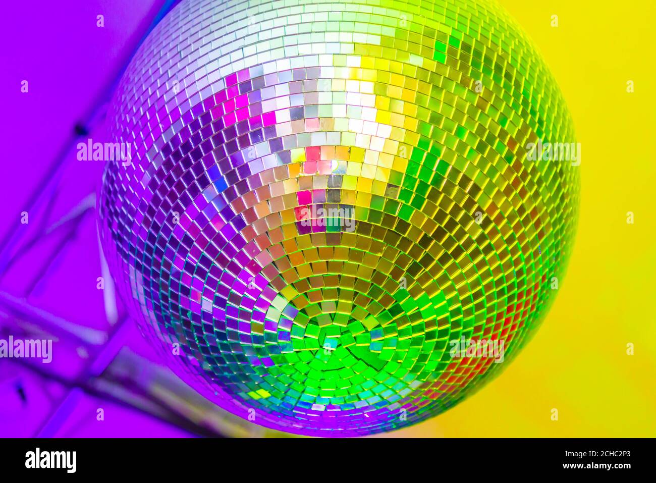 Big disco ball on a colored background Stock Photo - Alamy
