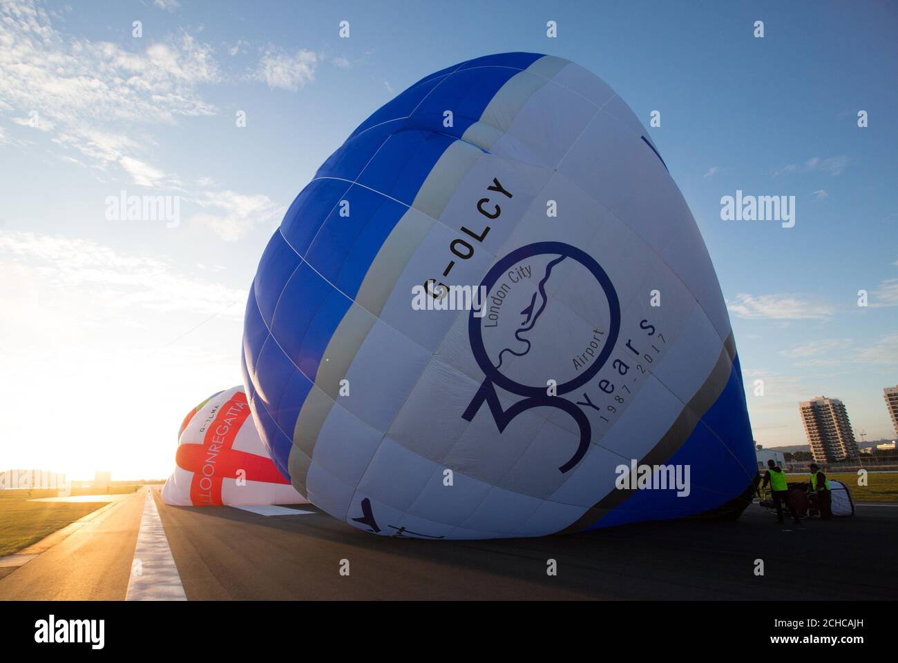 EDITORIAL USE ONLY 30 hot air balloons lift off from the runway at ...