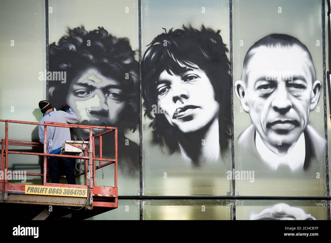 Bristol artist 'Voyder' works on a mural portrait of (left to right ...