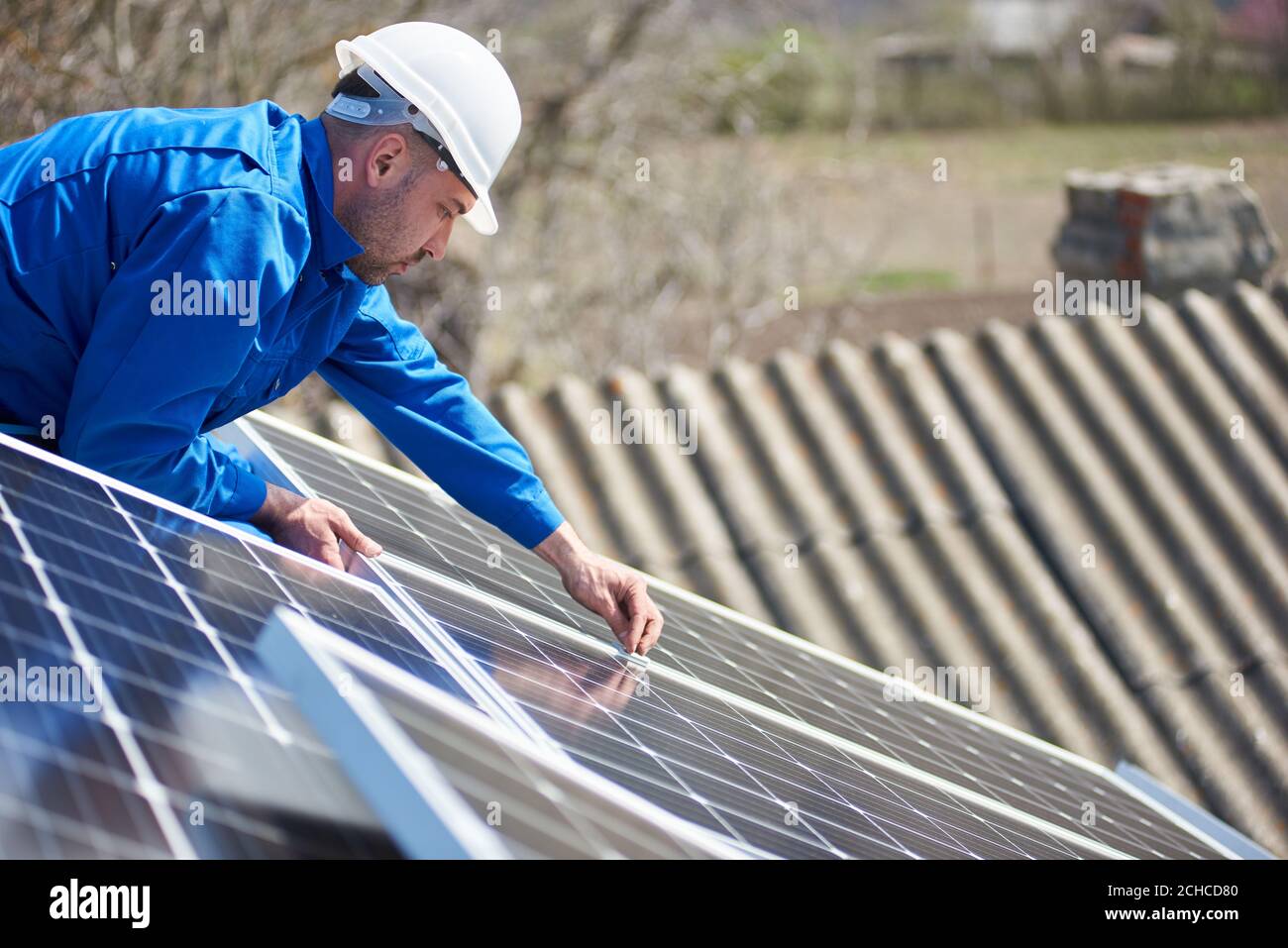 Male worker in blue suit and protective helmet installing stand-alone ...