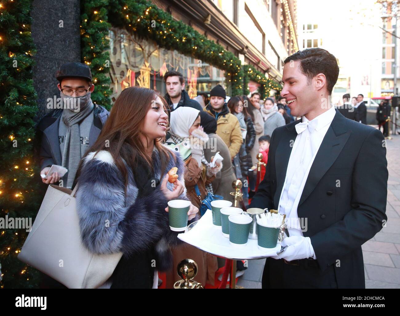 EDITORIAL USE ONLY Shopper Emmilyana Ariff is served a drink by Harrods ...