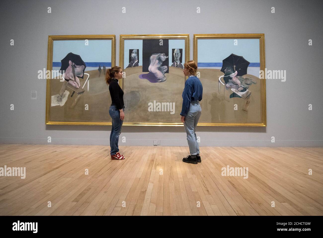 Visitors look at Francis Bacon's Triptych 1974-77 during a photocall ...