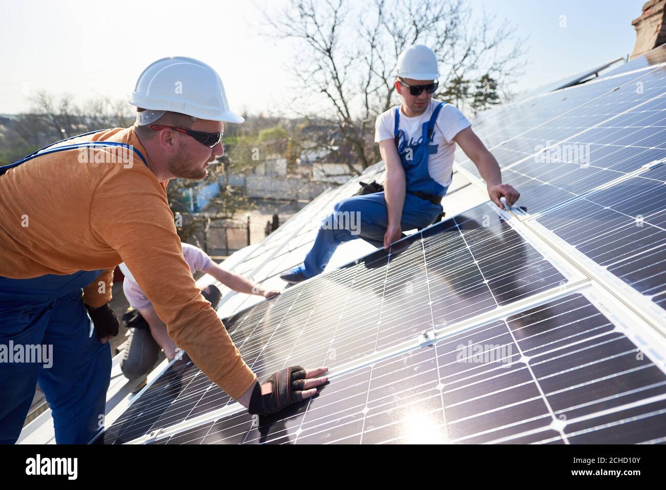 Male engineers installing solar photovoltaic panel system. Electricians ...