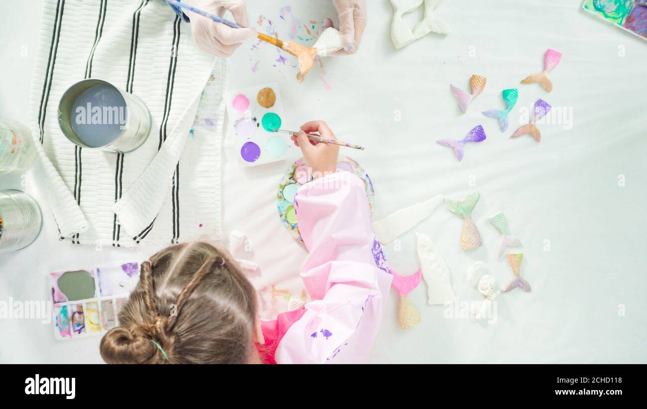 Flat lay. Step by step. Mother and daughter painting mermaid tails and ...
