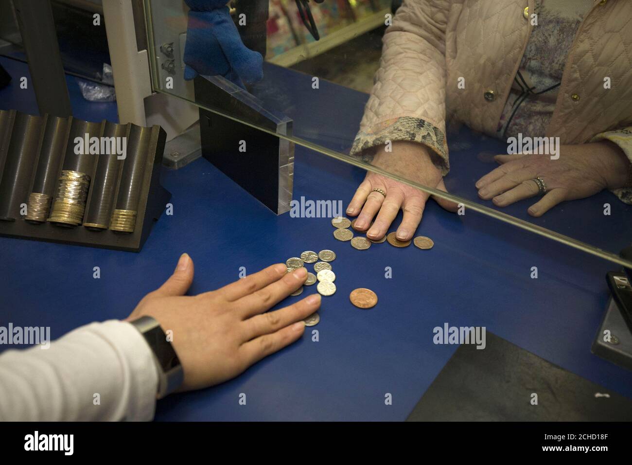 EMBARGOED TO 0001 MONDAY APRIL 23 EDITORIAL USE ONLY A cashier gives ...