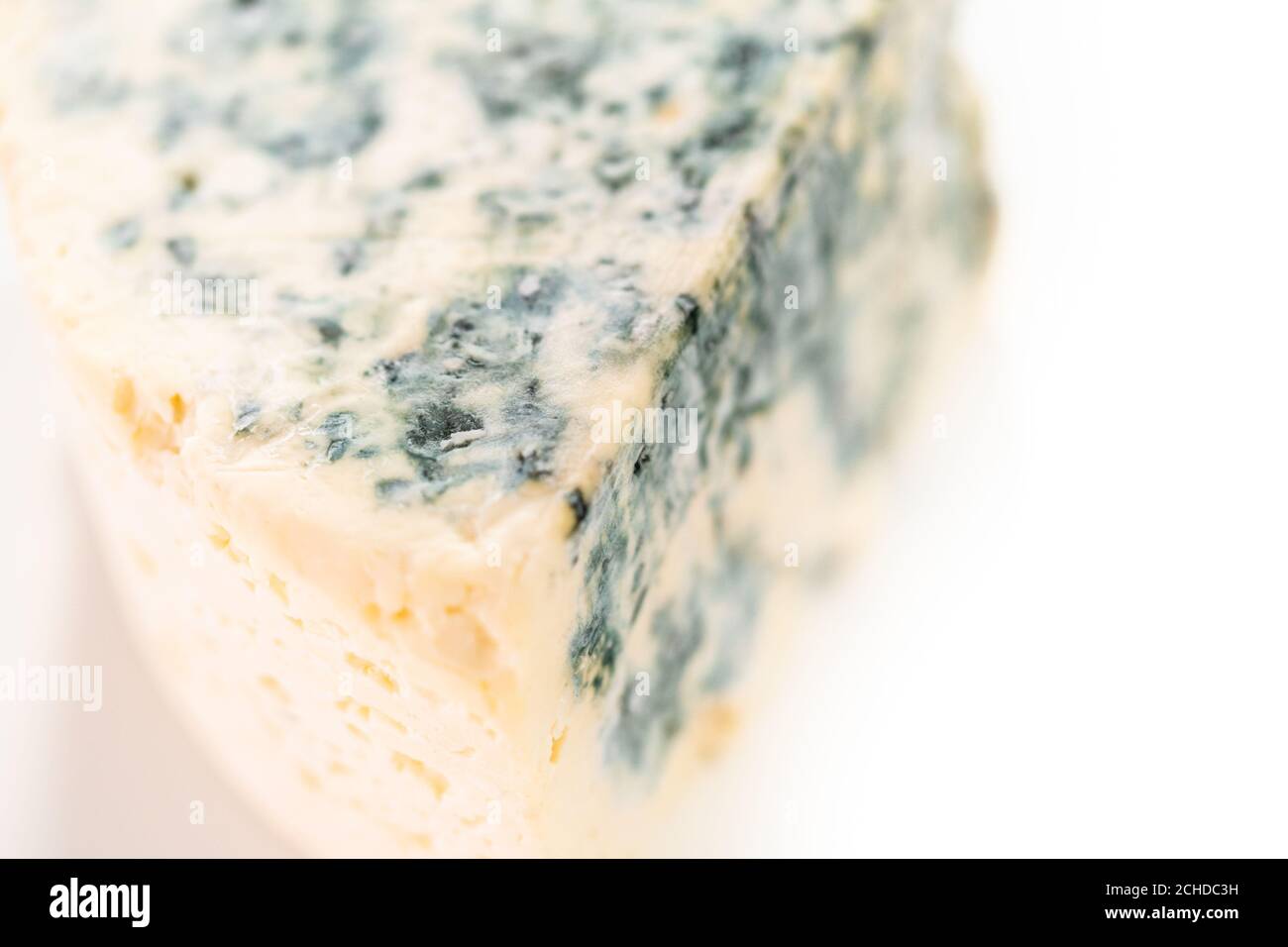 Large slice of blue cheese on a white background Stock Photo - Alamy