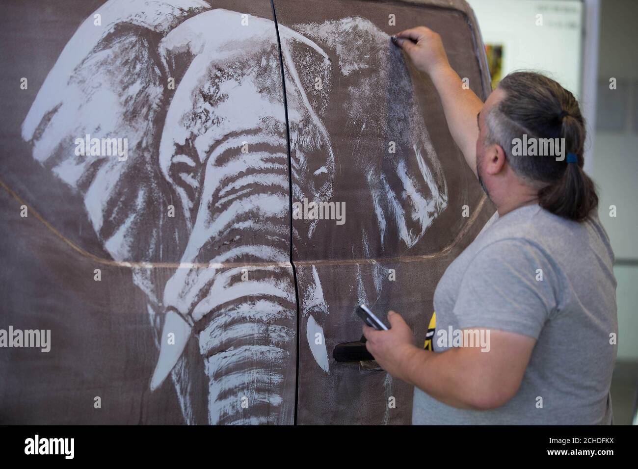 EDITORIAL USE ONLY Artist Ricky Minns, aka 'Ruddy Muddy' creates a ...