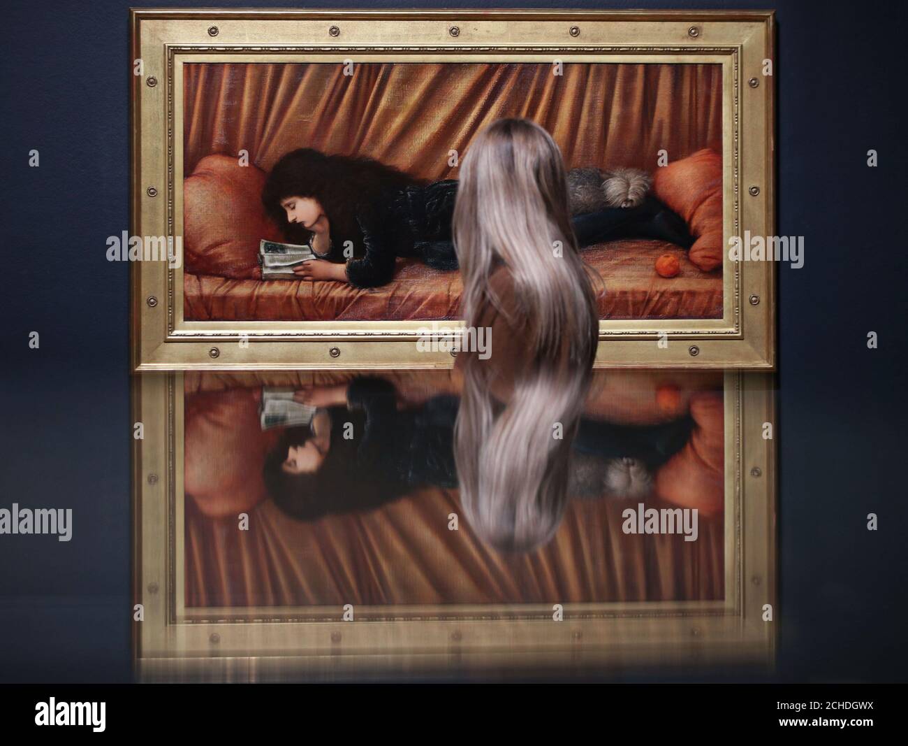 A visitor looking at Portrait of Katie Lewis, 1886, by Edward Burne ...