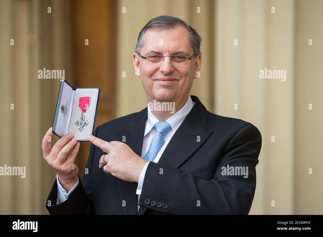 Denis Woulfe with his MBE medal, which was presented at an investiture ...