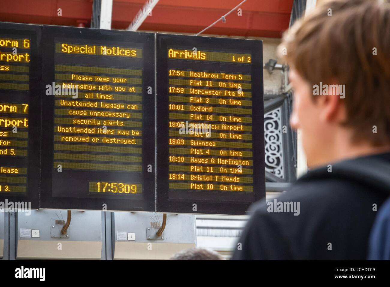 Back view of a passenger checking train timetable at London Paddington ...