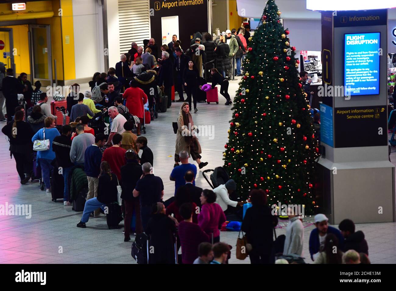Passengers stranded queue for information at Gatwick airport which has ...