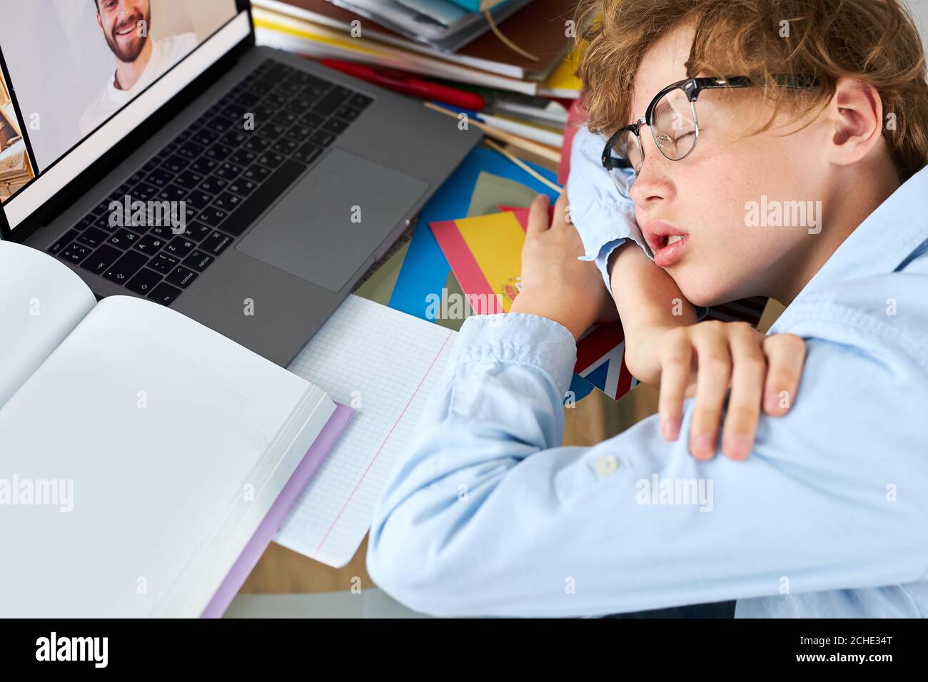 sleepy exhausted teen boy want to sleep, he is tired to study. he sits ...