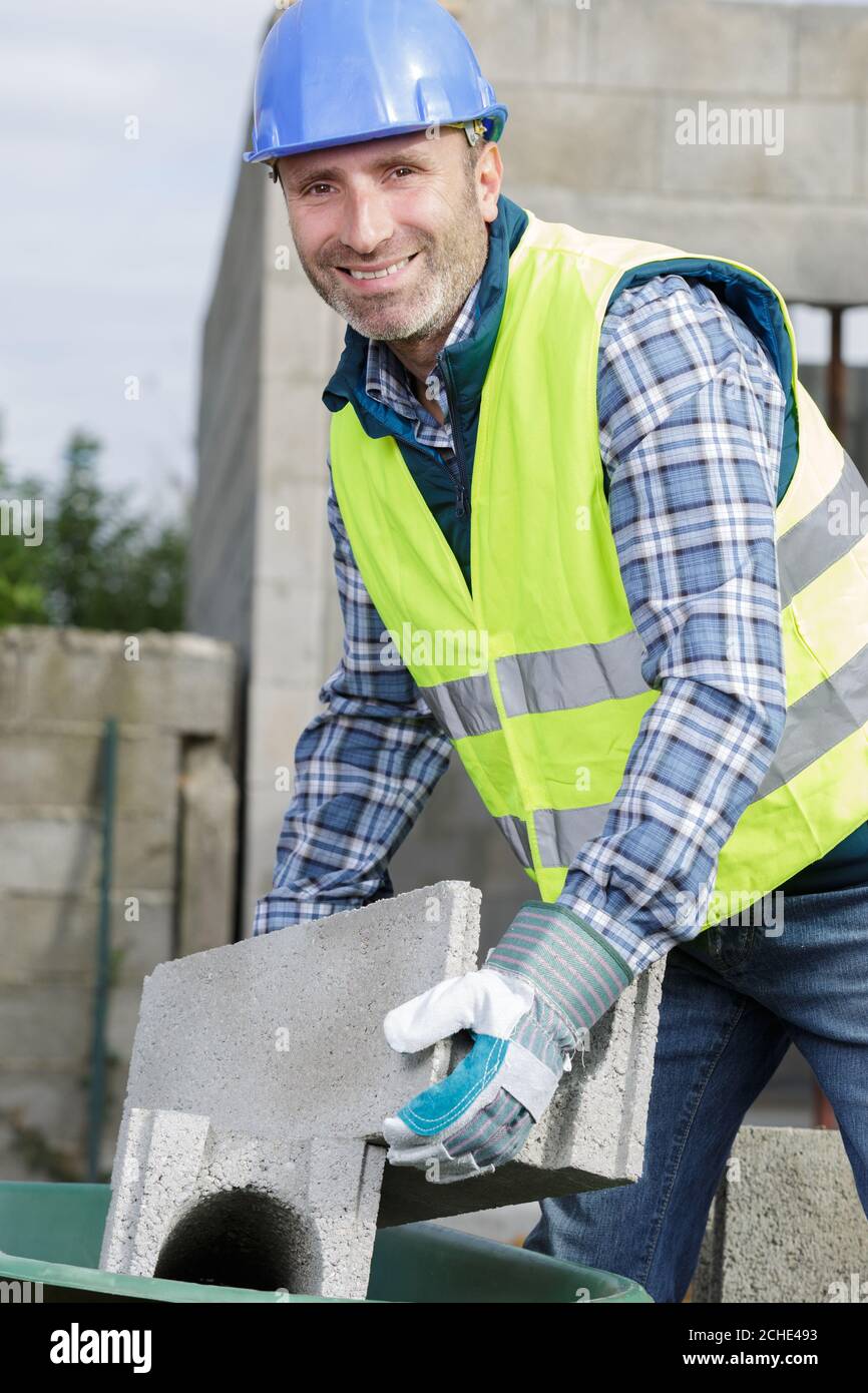 man bricklayer is catch cement brick blocks Stock Photo - Alamy
