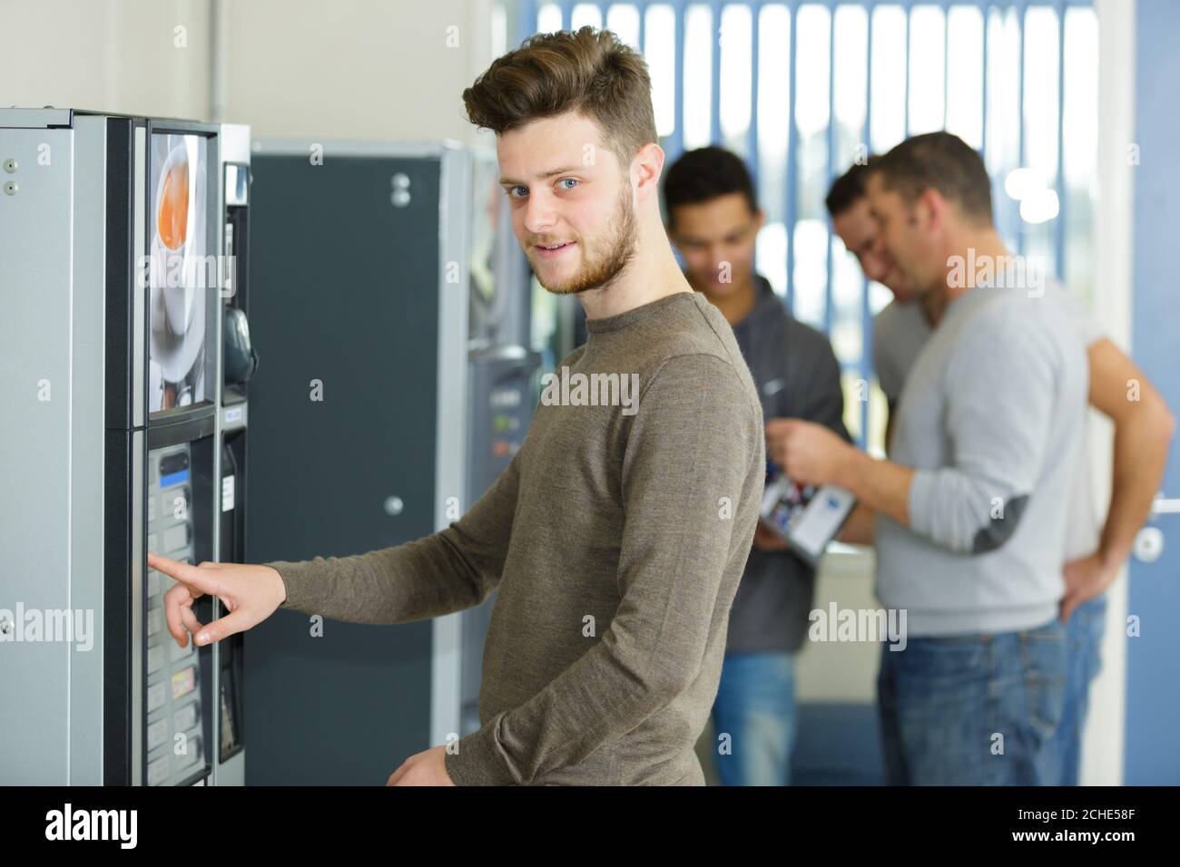 young man using a vending machine Stock Photo - Alamy