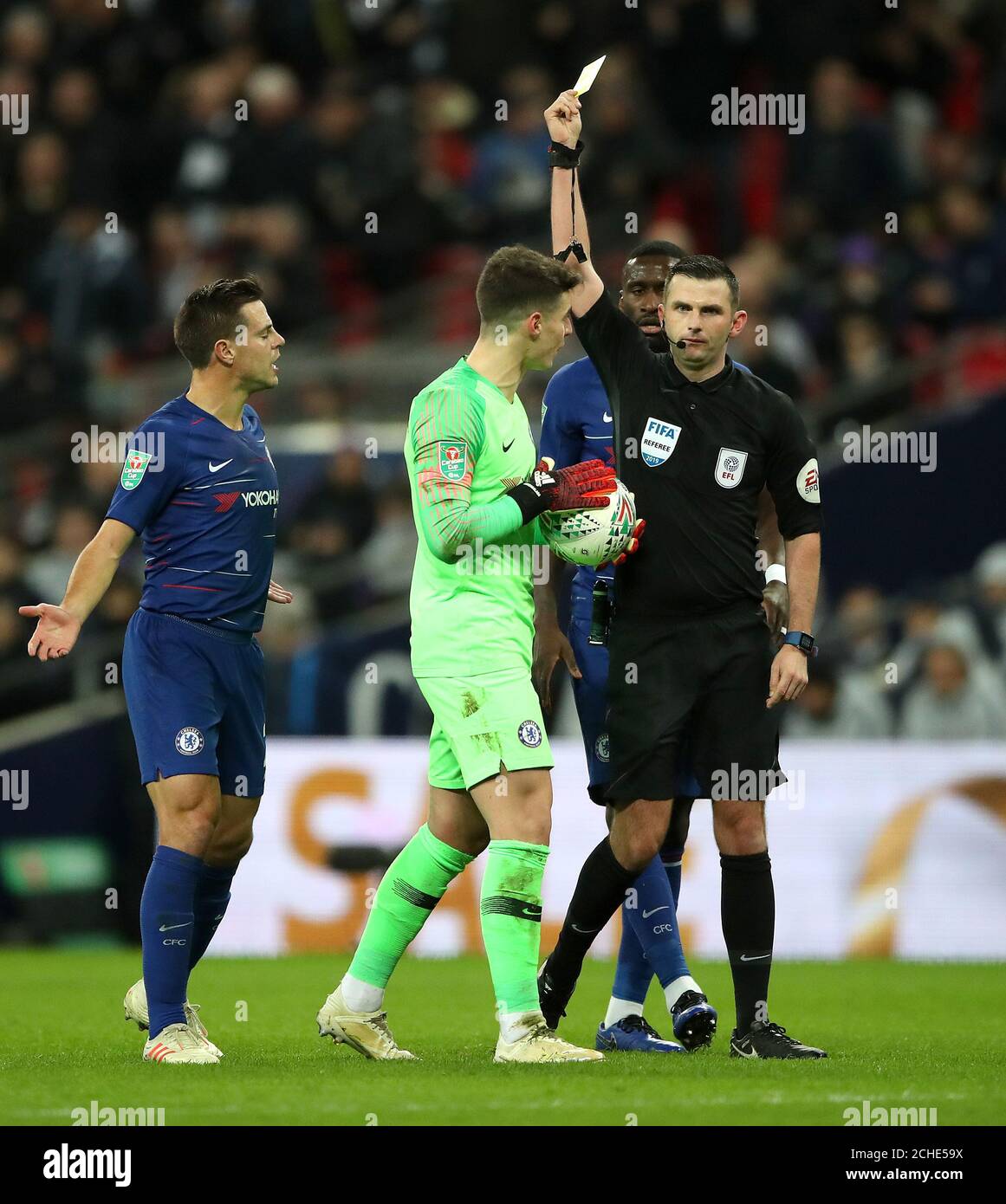 Chelsea goalkeeper Kepa Arrizabalaga is shown a yellow card by referee ...