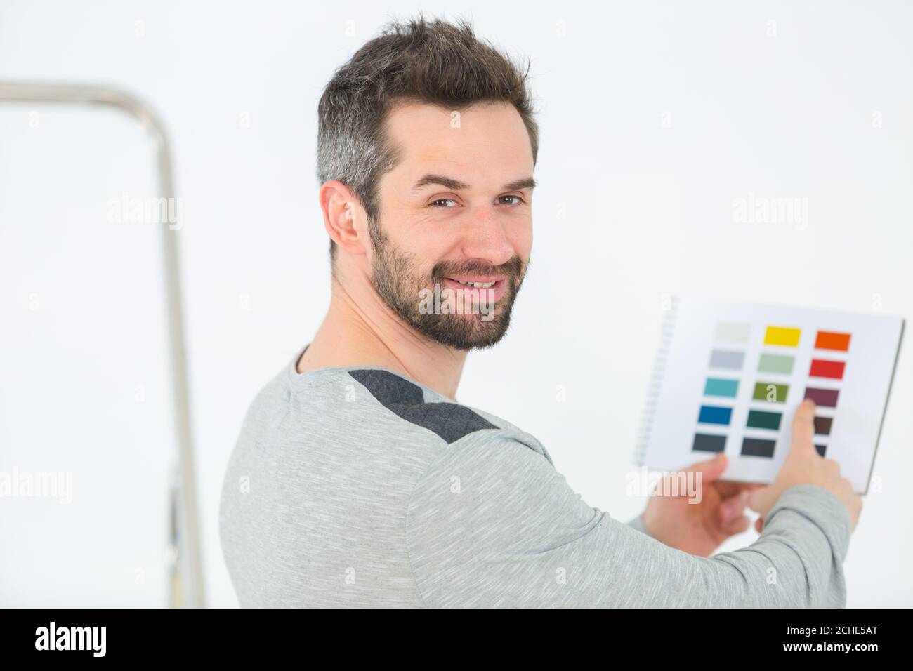 handsome painter with color swatches in his hands Stock Photo - Alamy