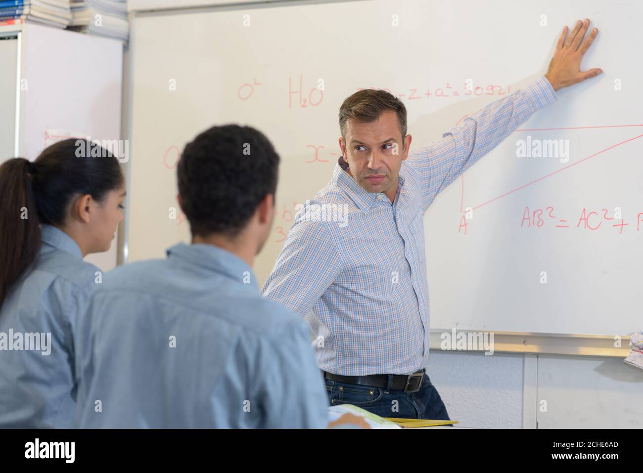 teacher showing formula on whiteboard to university class Stock Photo ...