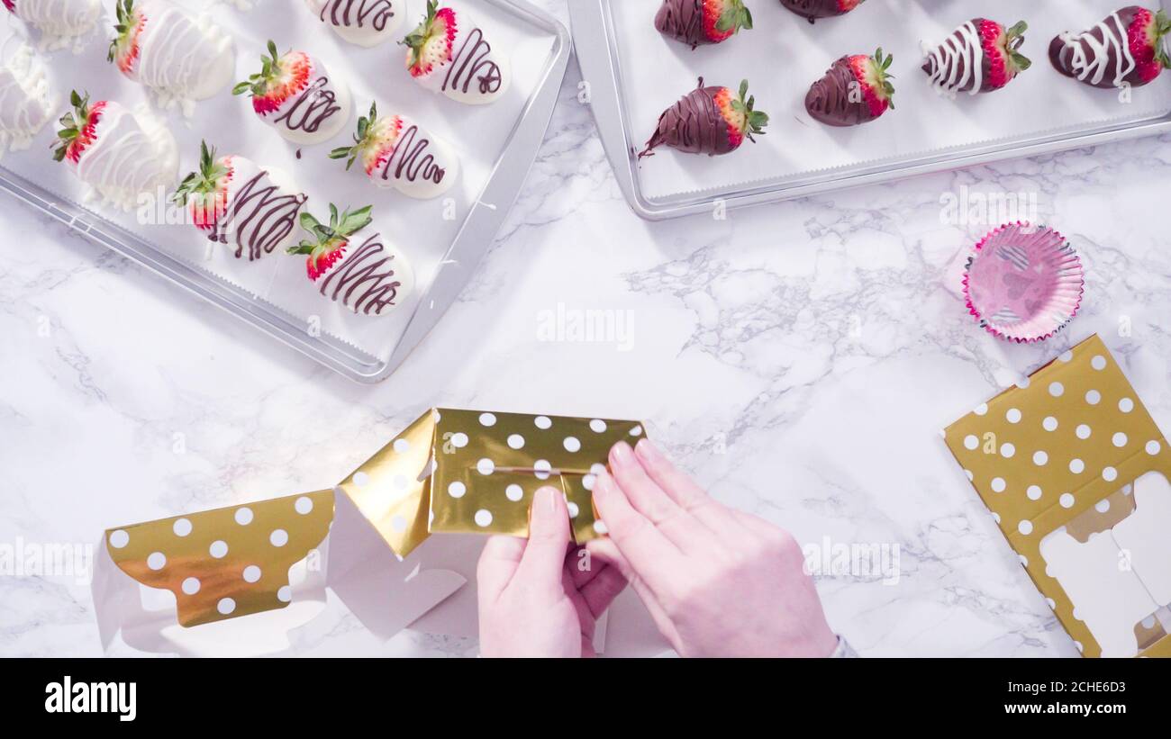 Flat lay. Step by step. Packaging chocolate dipped strawberries into a ...