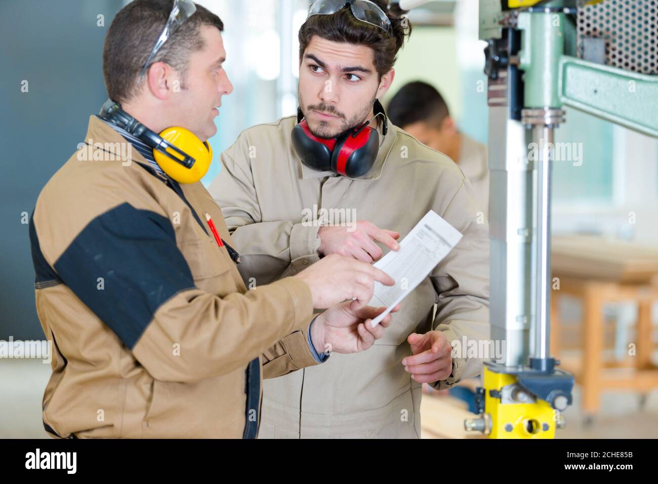engineer teaching apprentice to use milling machine Stock Photo - Alamy