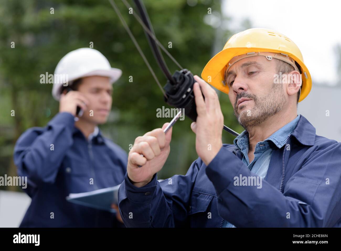man working outdoors making adjustment with spanner Stock Photo - Alamy