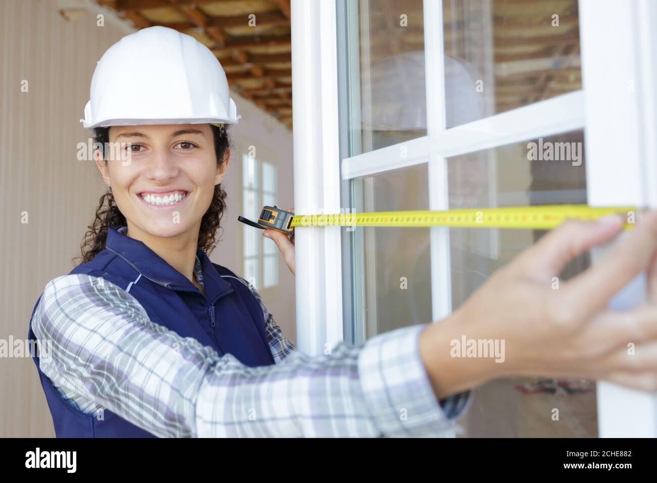 beautiful young woman measuring a window Stock Photo - Alamy