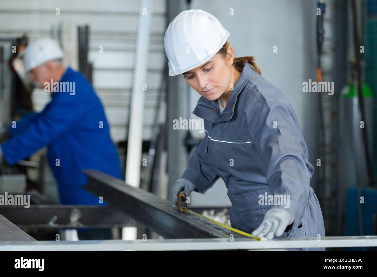 femal factory worker measuring metal Stock Photo - Alamy