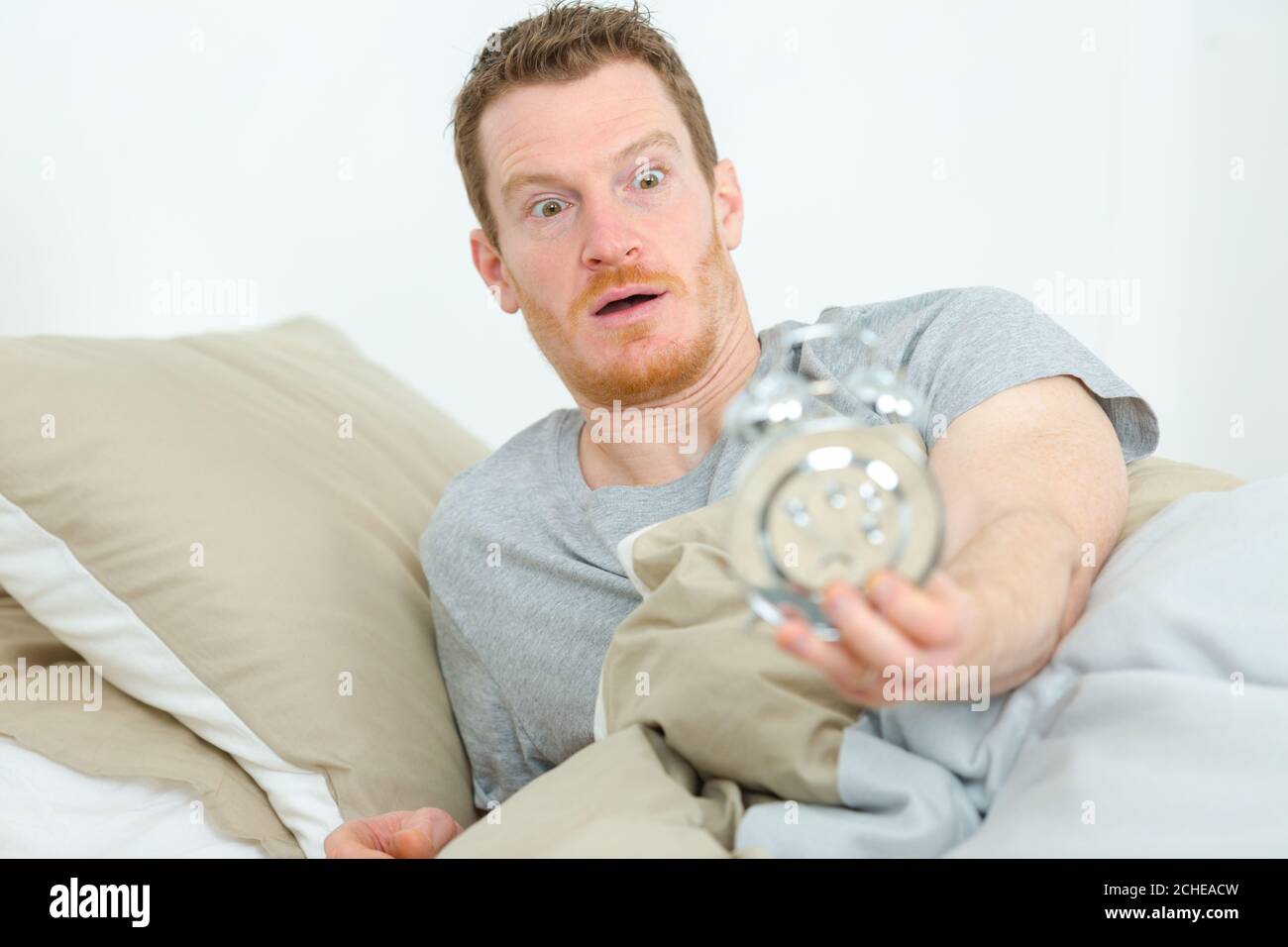 portrait of man waking up late Stock Photo - Alamy
