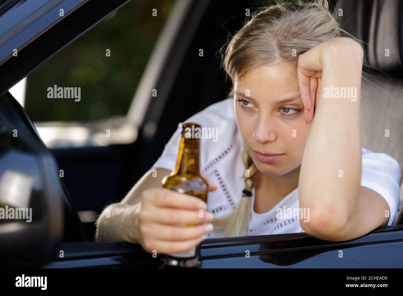 drunk woman driving and holding beer bottle inside a car Stock Photo ...